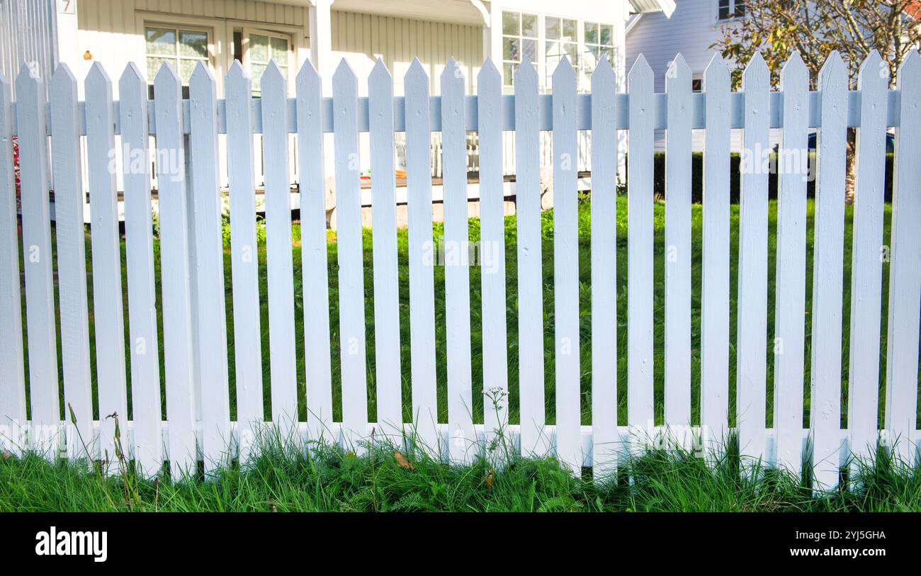 fence of a white wooden garden in front of windows on white facade of a ...