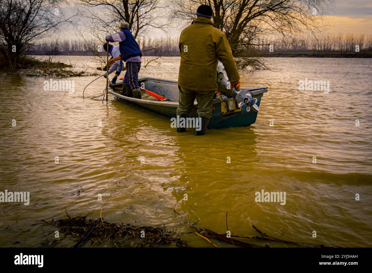 People going on boat trip on wide river who has flooded forest ground ...