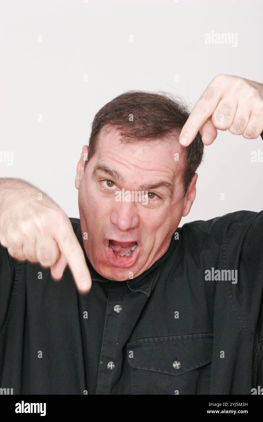 Middle-aged man, with dark hair on white background, makes unusual face ...