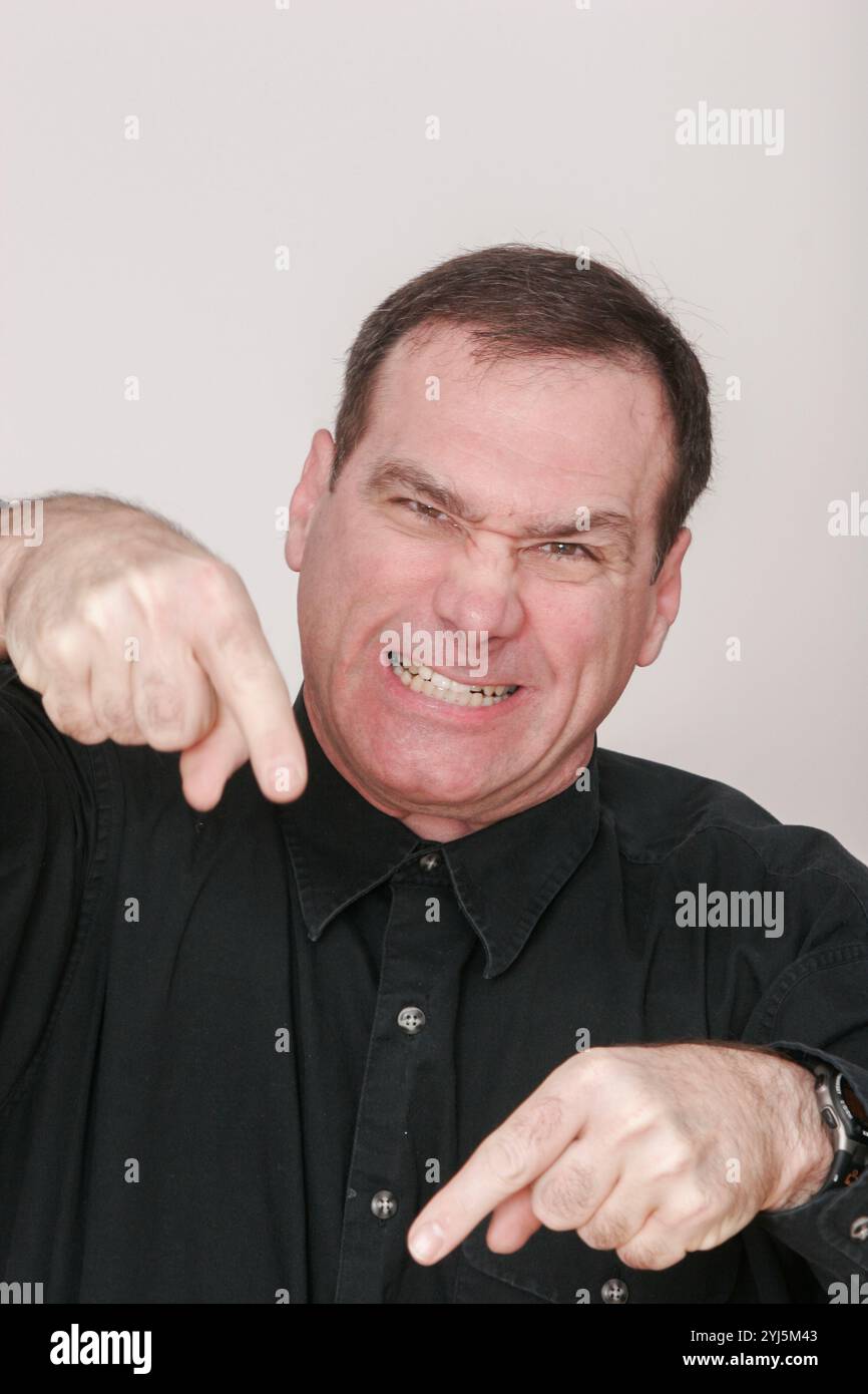 Middle-aged man, with dark hair on white background, makes unusual face ...