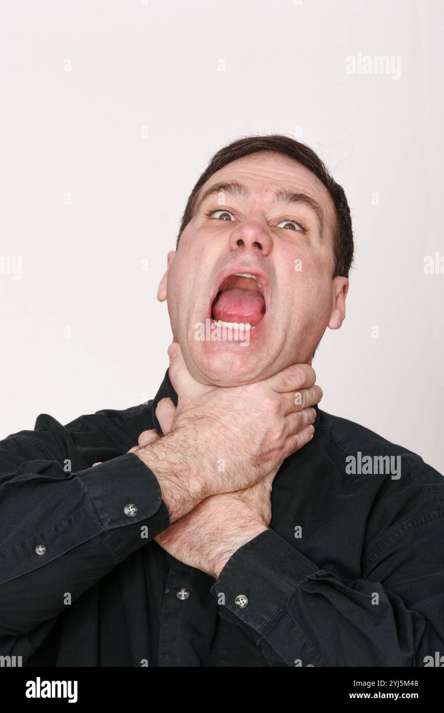 Middle-aged man, with dark hair on white background, makes unusual face ...