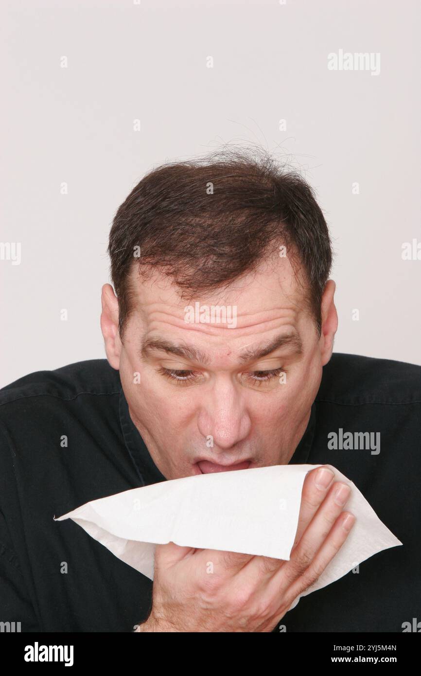 Middle-aged man, with dark hair on white background, makes unusual face ...