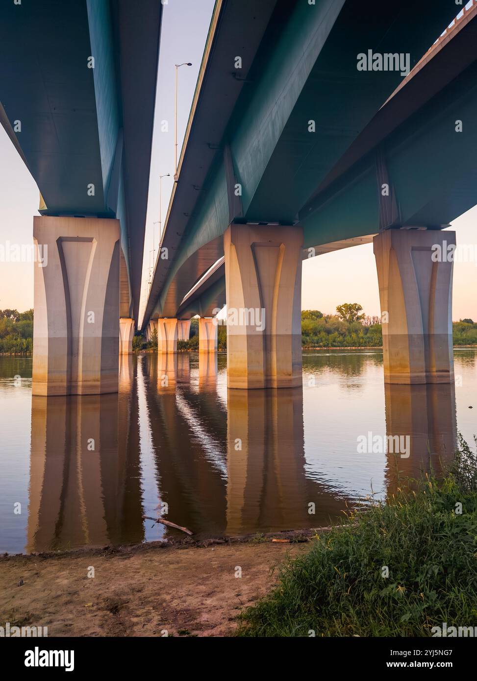 Under the Maria Skłodowska-Curie Bridge on the Vistula River at dusk ...