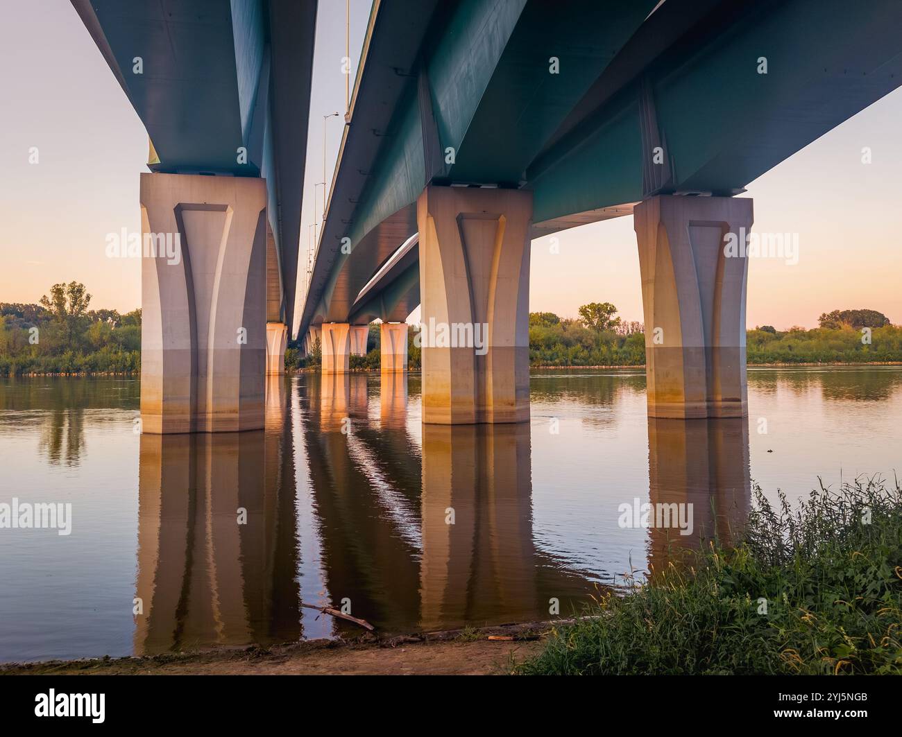 Under the Maria Skłodowska-Curie Bridge on the Vistula River at dusk ...