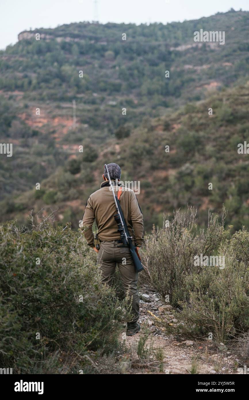Hunter walking in the woods carrying rifle on shoulder Stock Photo - Alamy