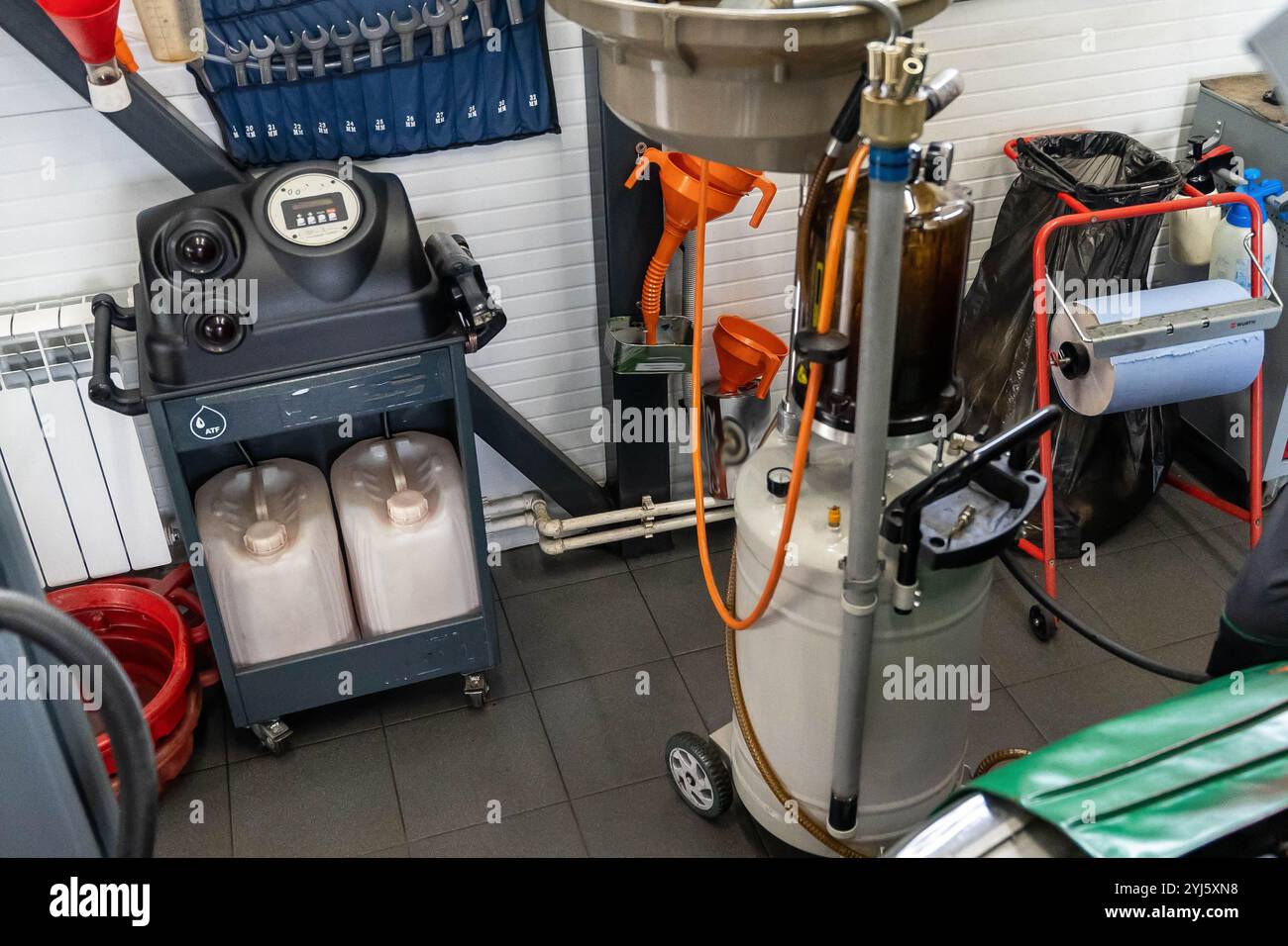 A variety of tools and equipment are arranged for vehicle servicing. a ...