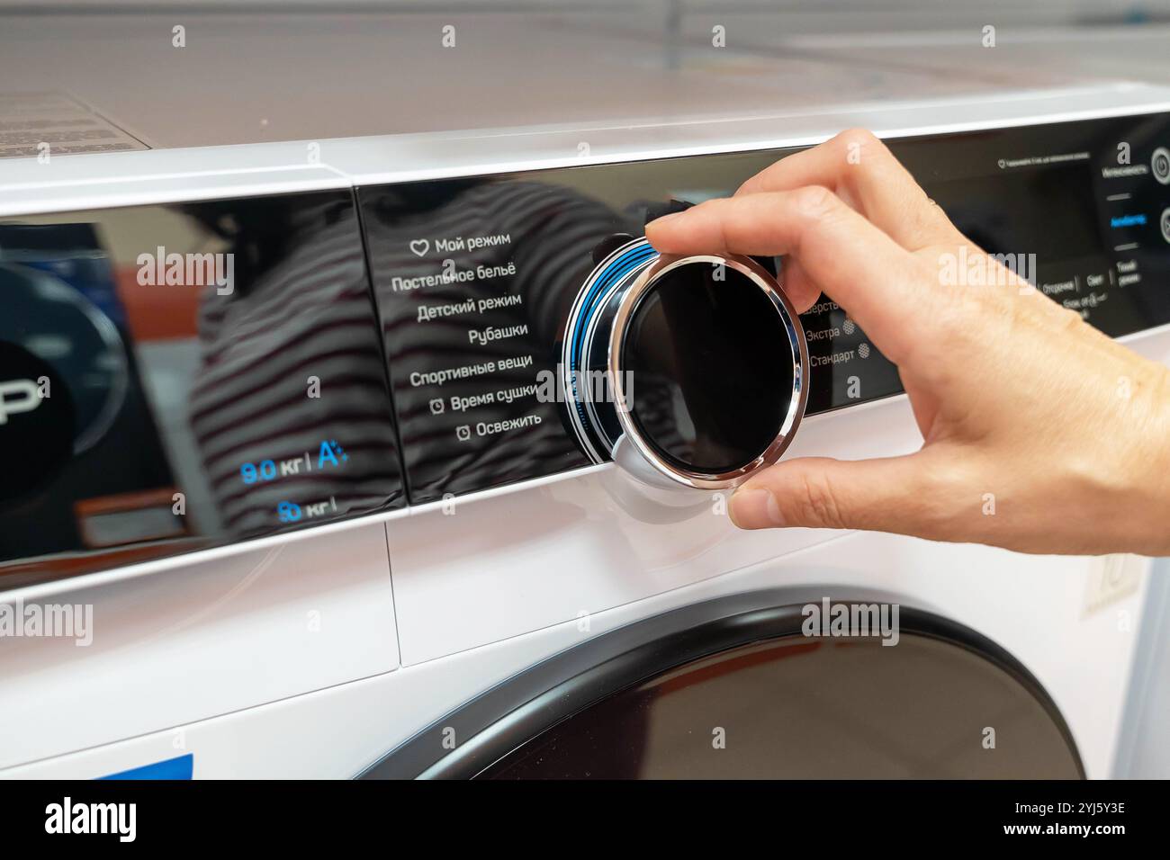 A person operates the control knob on a washing machine Stock Photo - Alamy