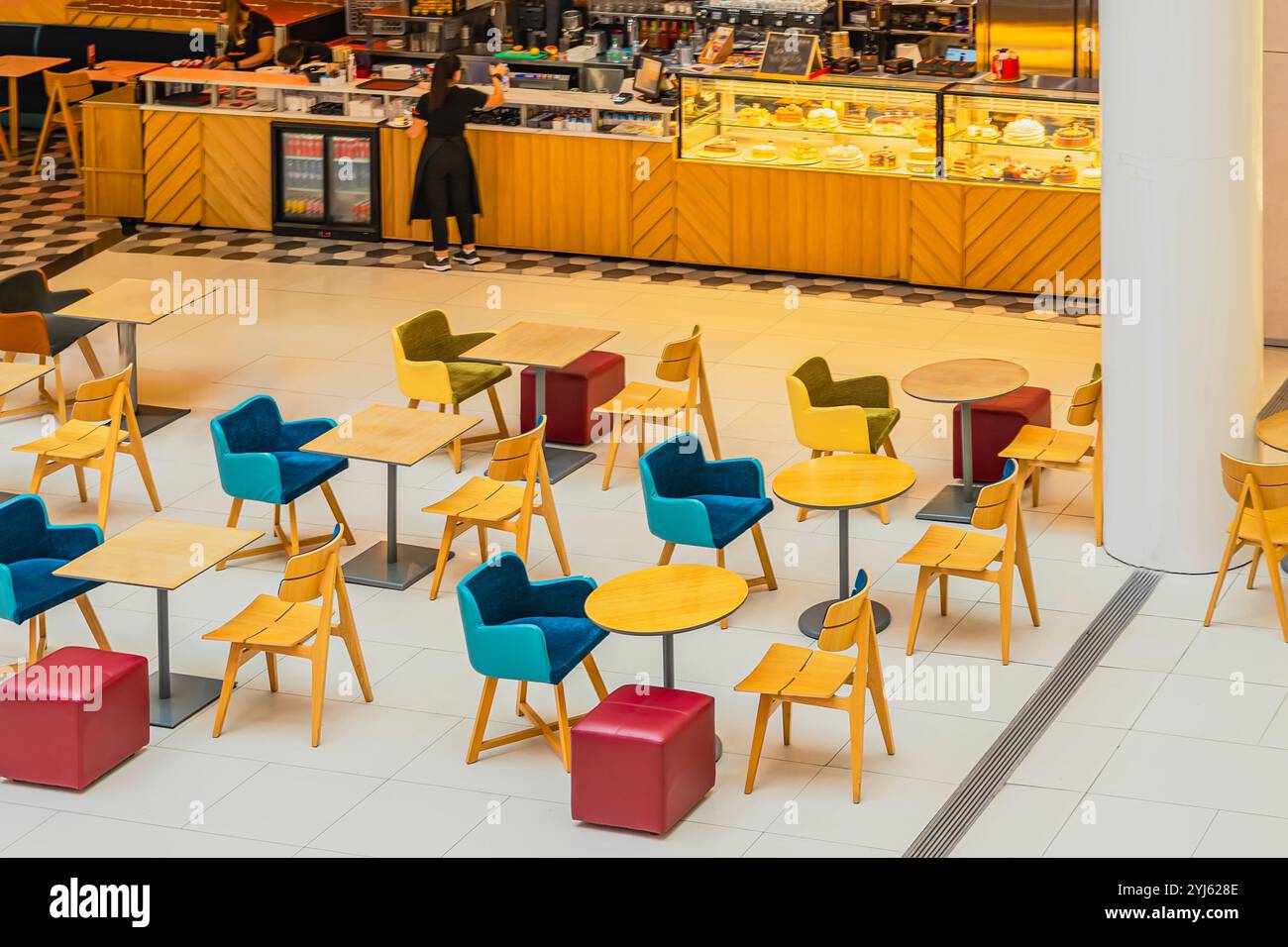 Empty modern cafe interior with colorful chairs, tables, and a bright ...
