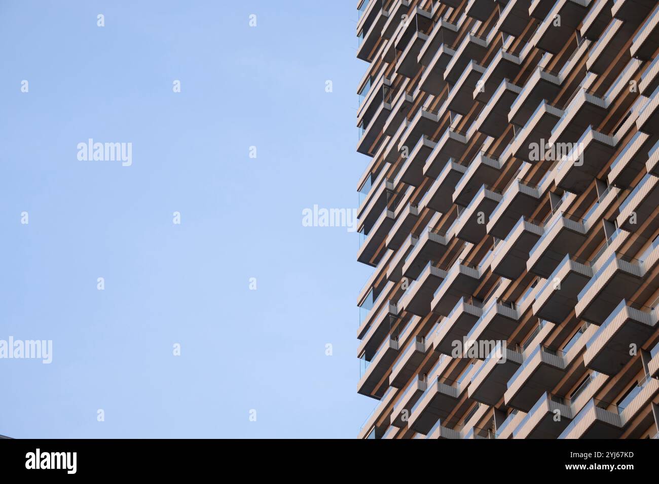 Modern architectural building facade with repetitive balcony patterns against blue sky Stock ...
