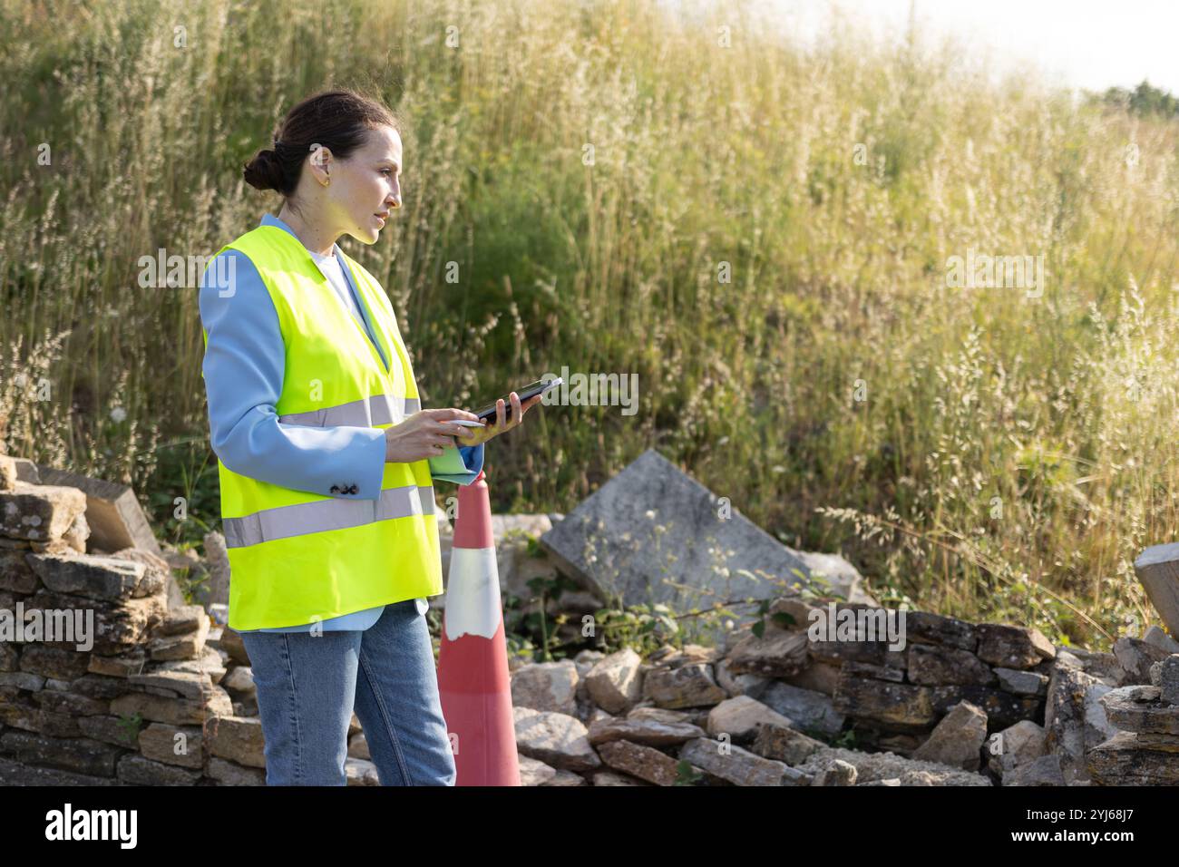 Female claims adjuster with her tablet conducting an assessment of the ...