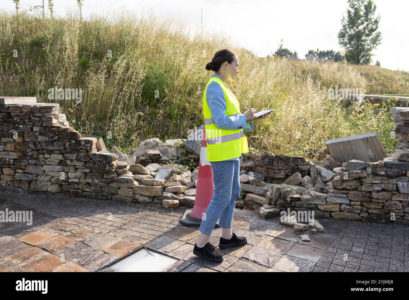 A female insurance adjuster with her tablet examining the damage to a ...