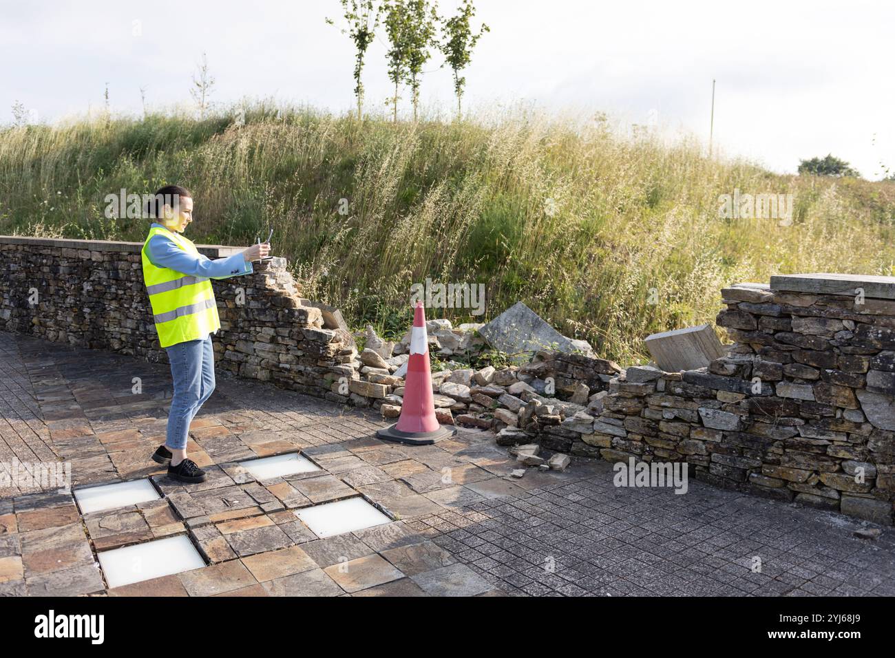 Insurance claims adjuster taking a photo with her tablet to a damaged ...
