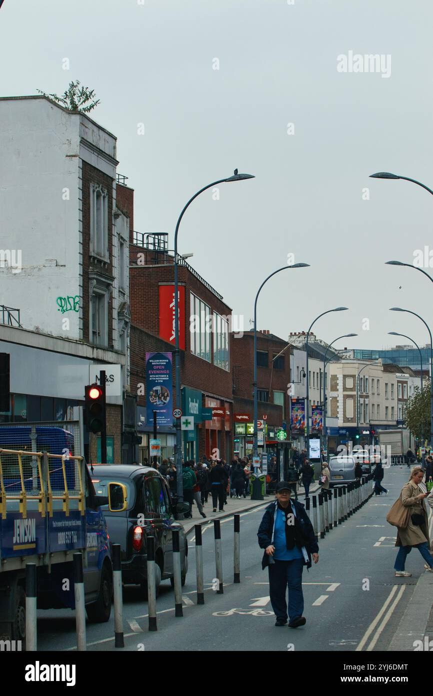 A street scene in a city, with multiple streetlights and a line of ...