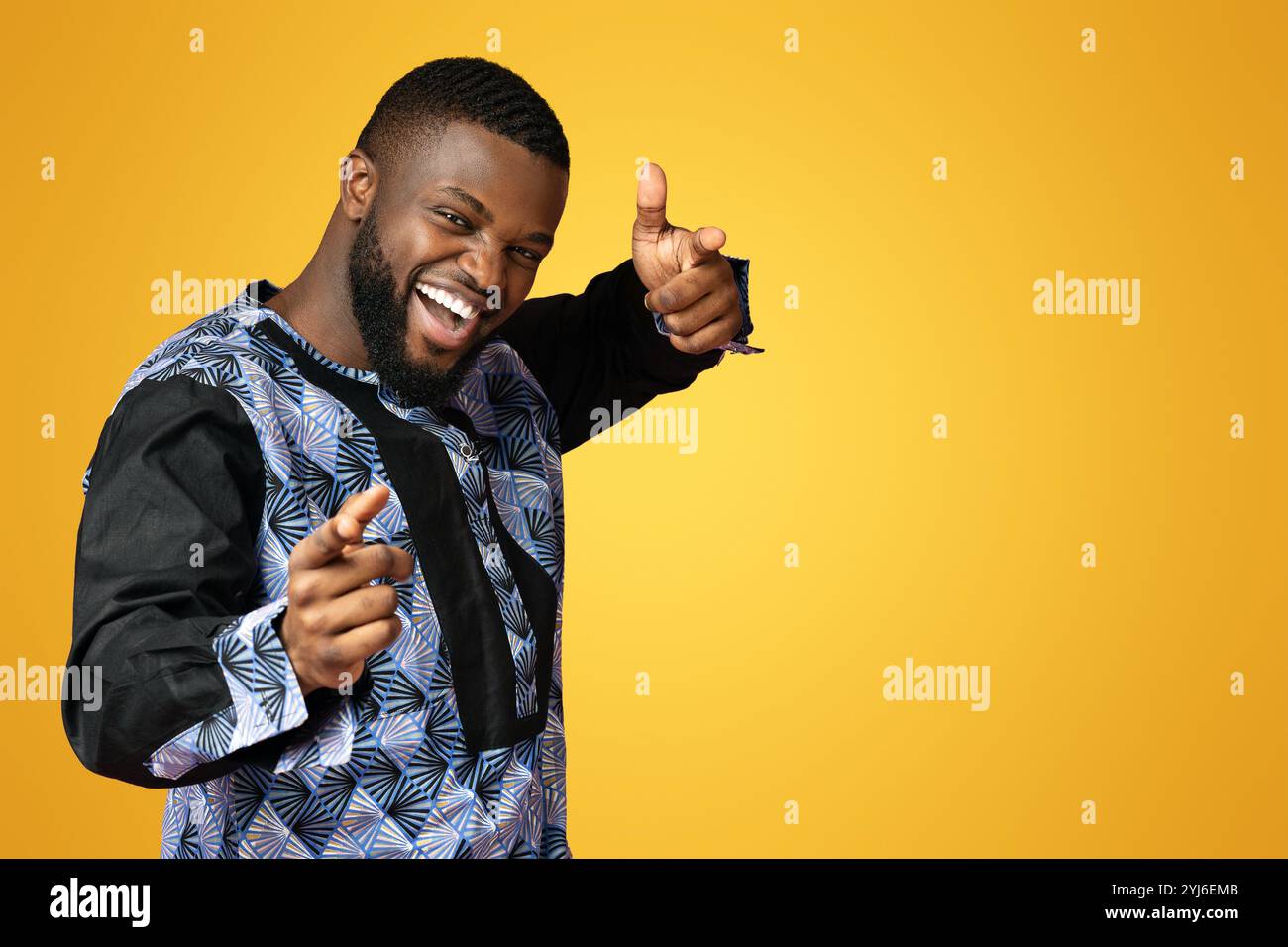 Handsome black young man in traditional african costume, indicating to ...