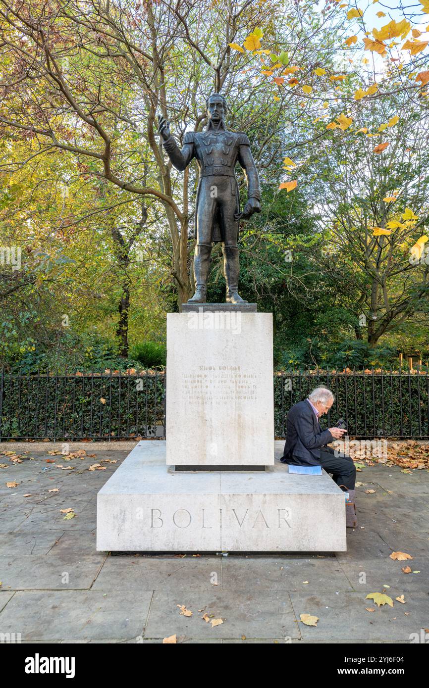 A man sits on the plinth of Hugo Daini's Sculpture of Simon Bolivar in ...