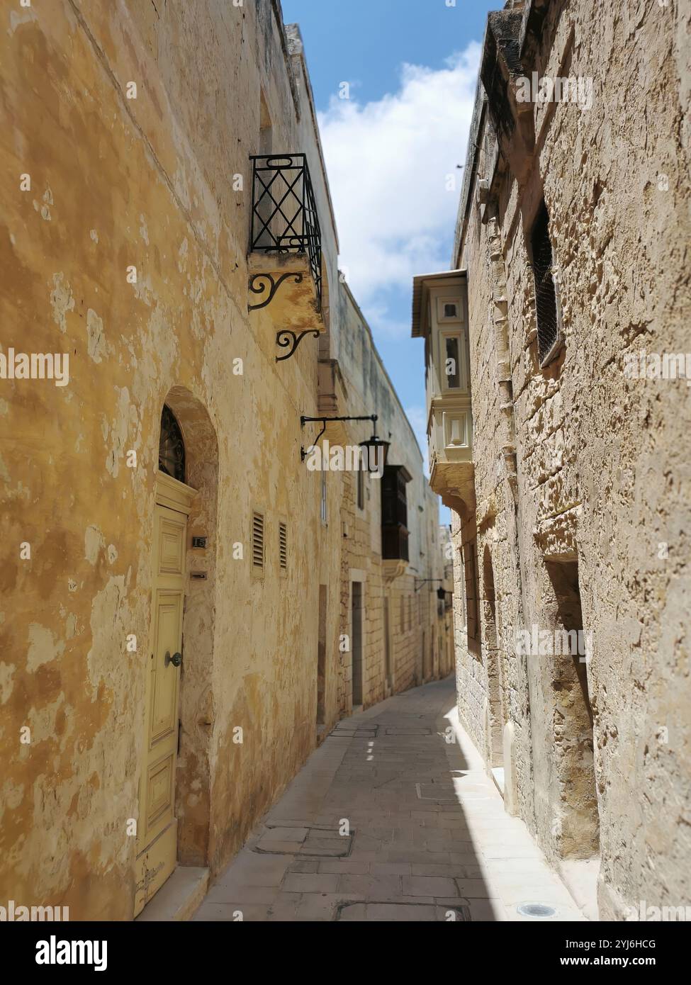 Narrow historic alleyway with rustic stone walls and traditional ...