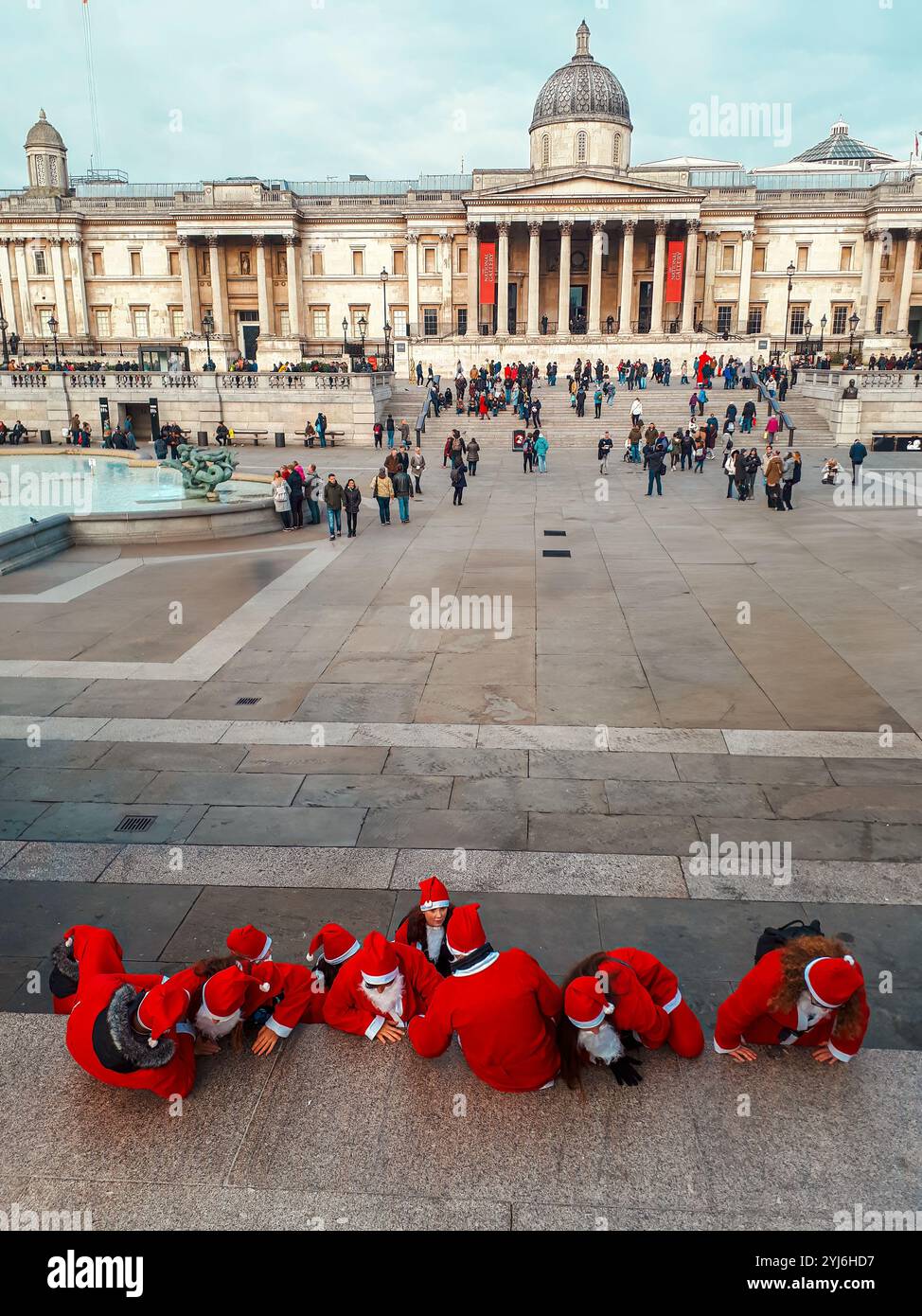 Group of people dressed as Santa Claus gathered on the steps in ...