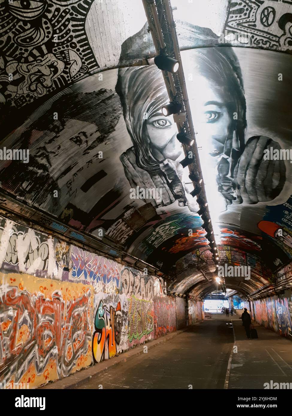 Vibrant graffiti-covered tunnel with striking black-and-white mural on ...