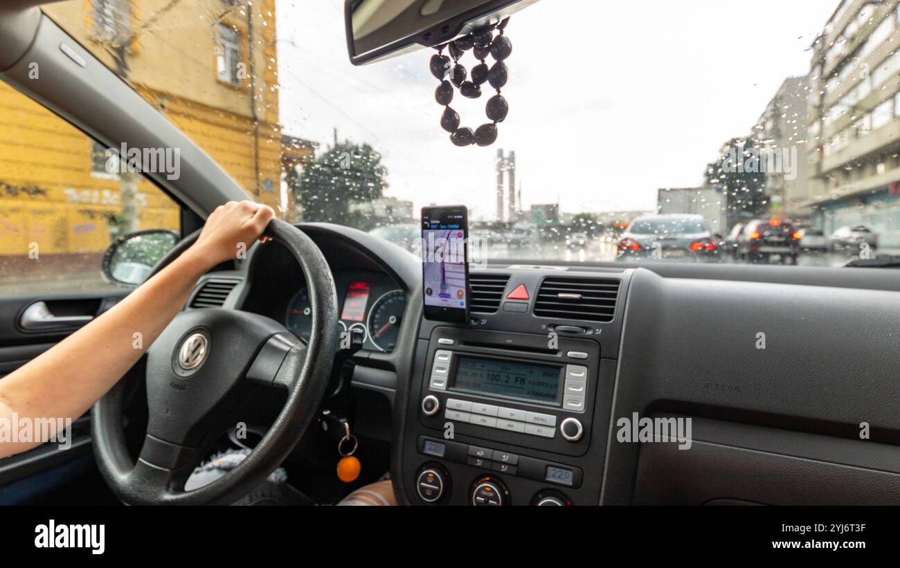 Smartphone showing Waze maps to show the way thru the city. Driver ...