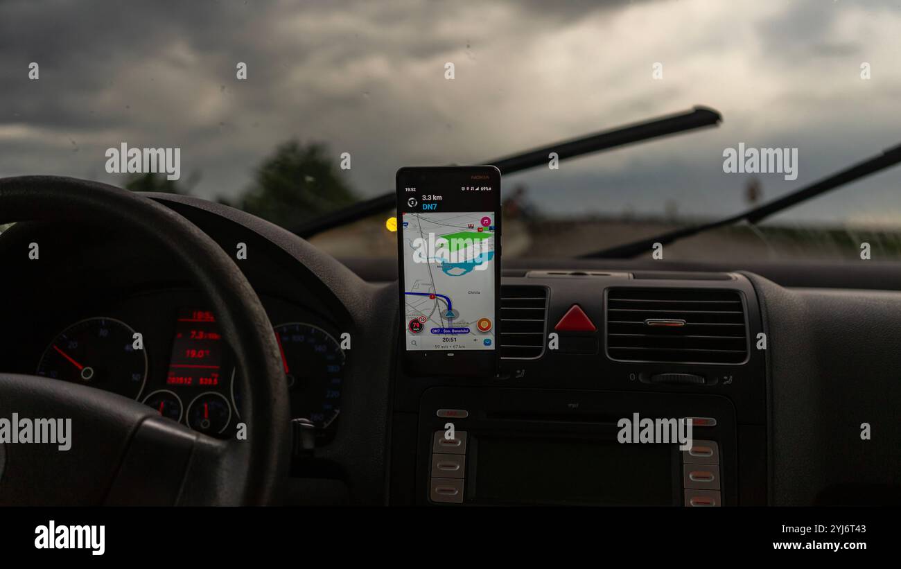 Smartphone showing Waze maps to show the way thru the city. Driver ...