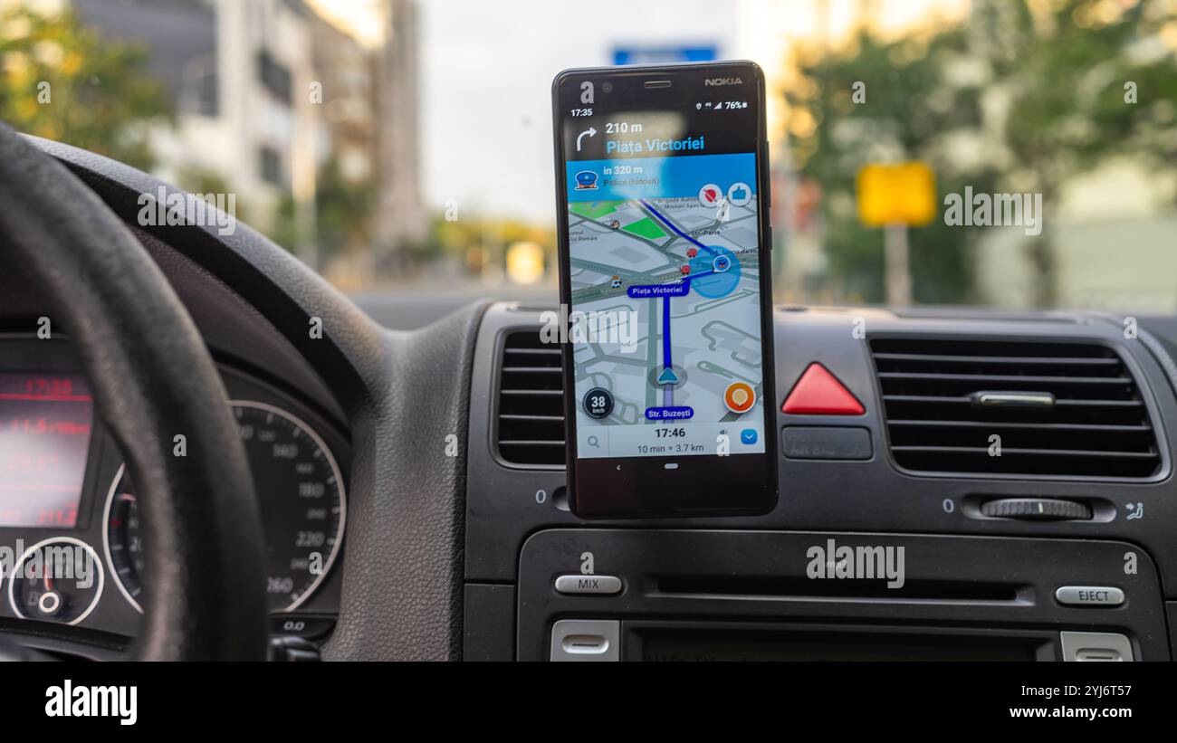 Smartphone showing Waze maps to show the way thru the city. Driver ...