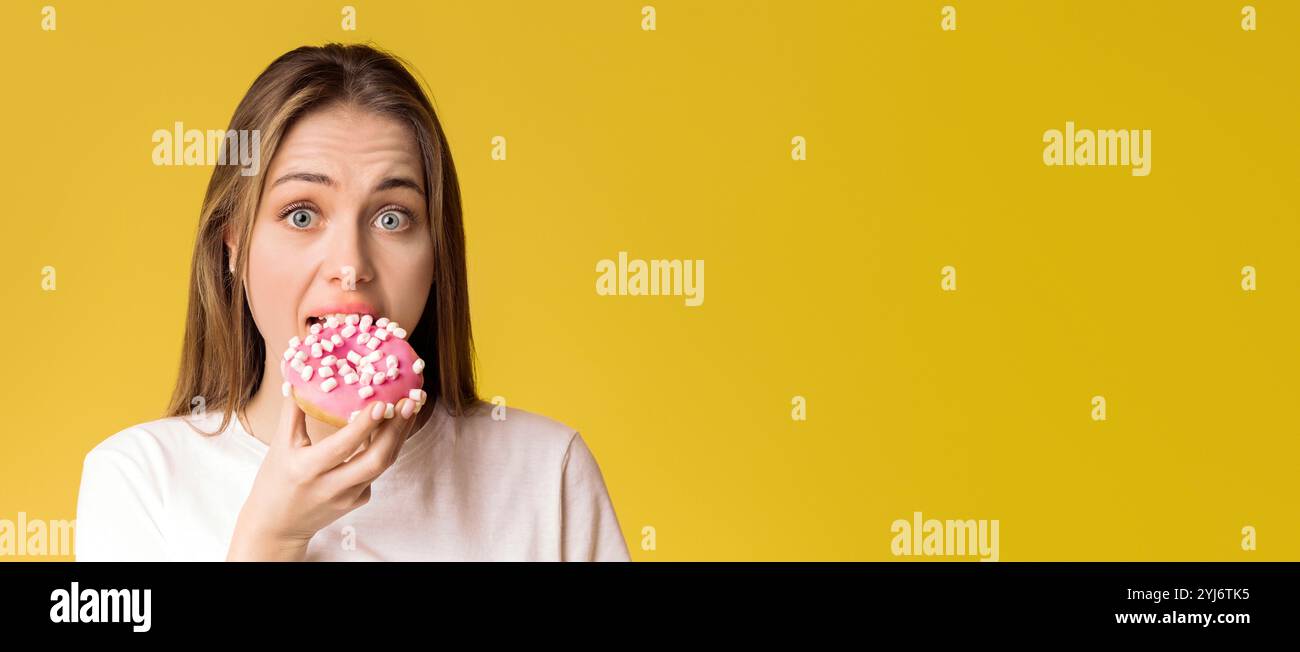 Young Lady Eating Donut, Preferring Unhealthy Food, Posing Over Yellow ...