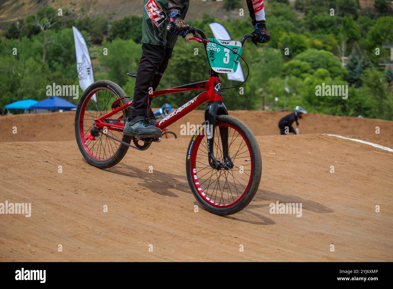 BMX bikes racing, people riding bikes on a bicycle motocross track in ...