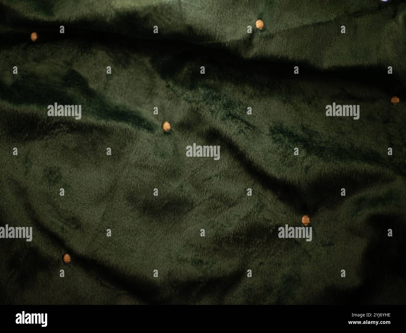 A green fabric with a pattern of small dots. The fabric is soft and ...