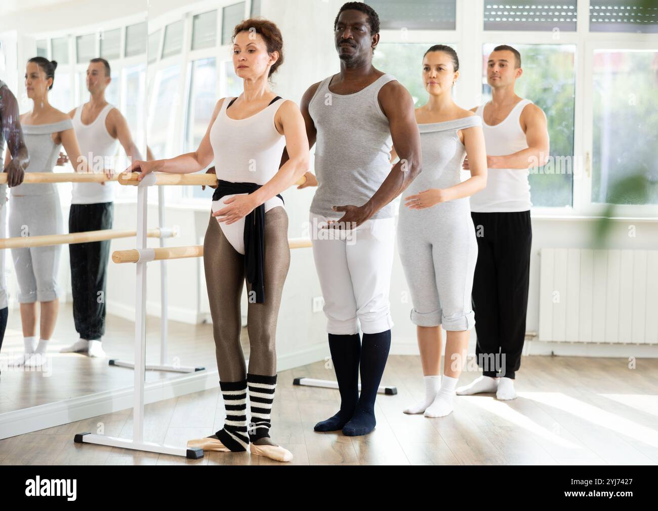 Group of dancers stand in first position at barre Stock Photo - Alamy