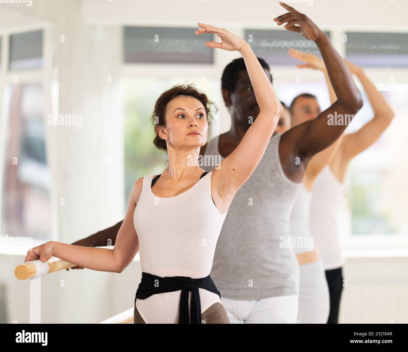 Female ballet teacher demonstrating third position at ballet class ...