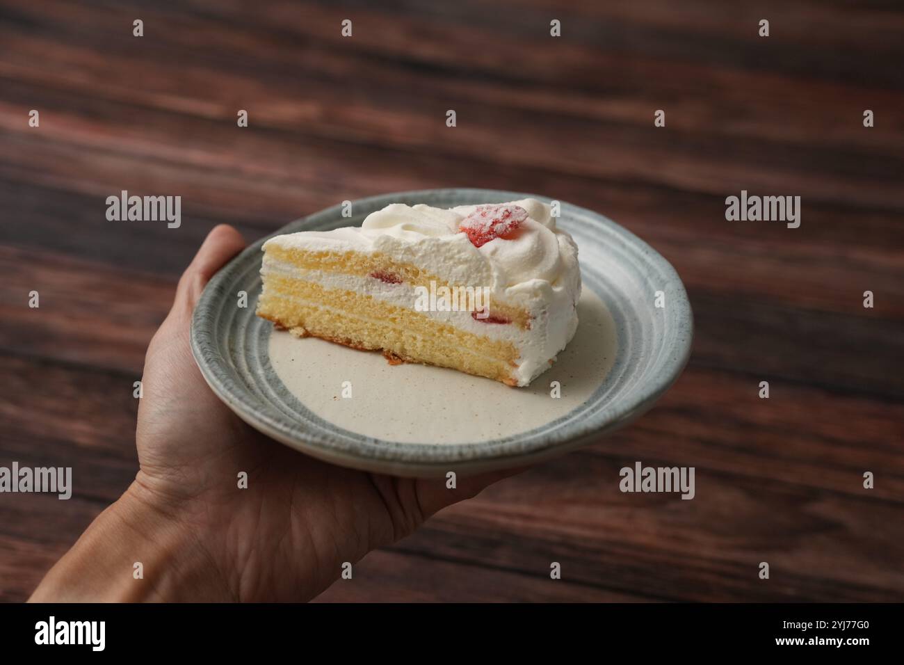 A yellow man's hand is about to eat a small Japanese strawberry ...