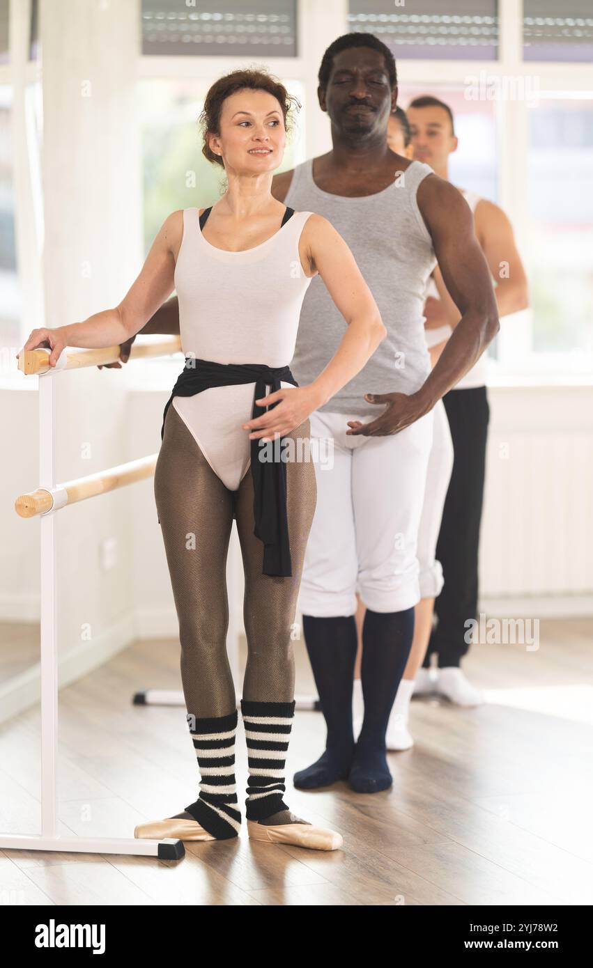 Group of dancers stand in first position at barre Stock Photo - Alamy