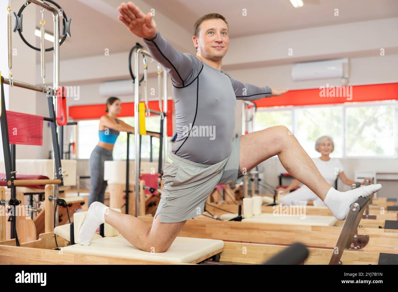 Man performs exercise on reformer to improve coordination, balance, and posture Stock Photo - Alamy