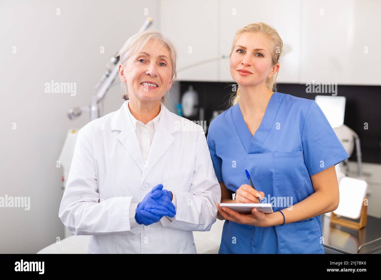Two professional female cosmetologists in clinic of aesthetic medicine ...