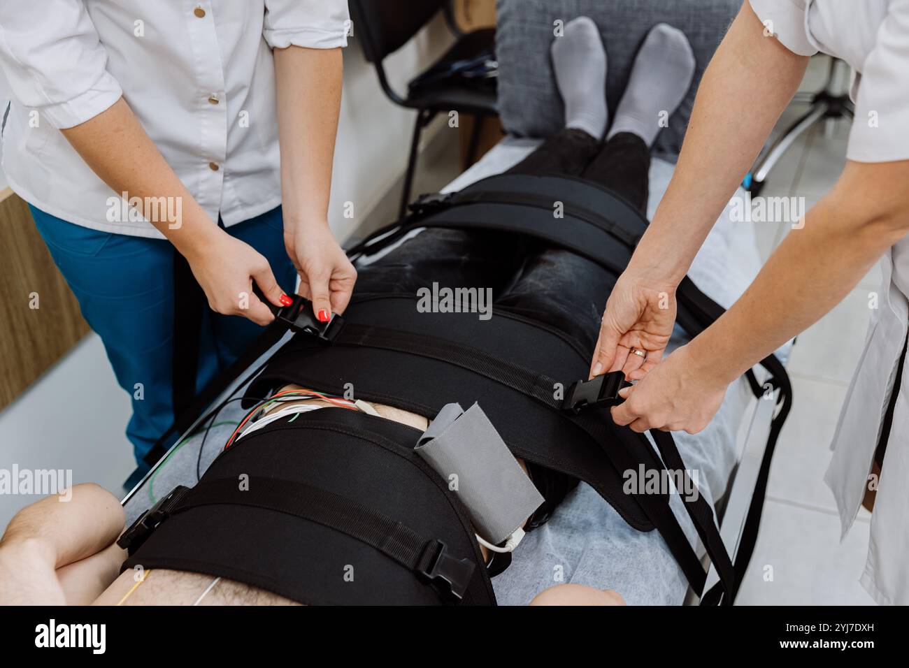 Healthcare professionals securing patient for physical therapy ...
