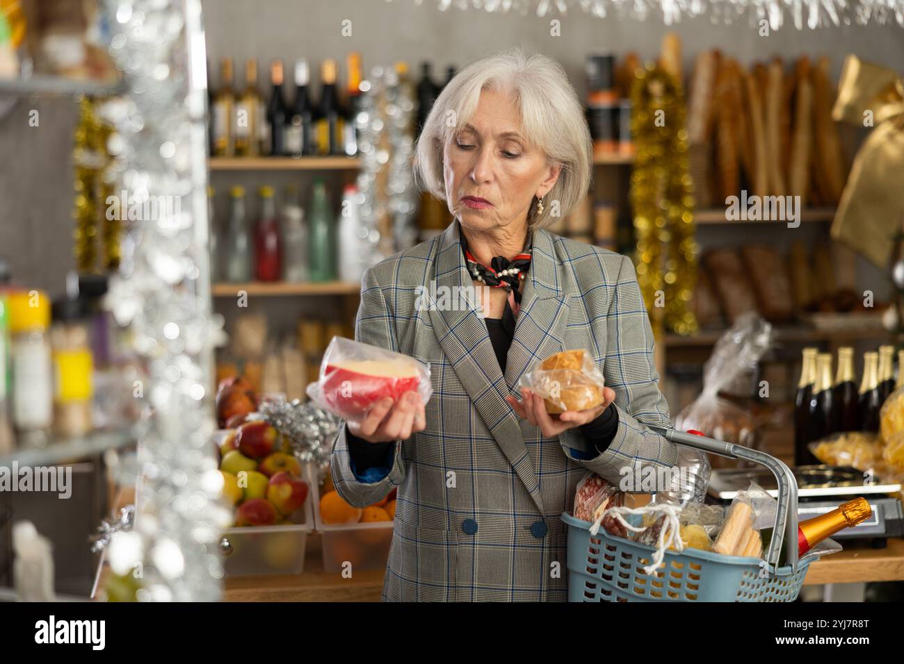 Elderly woman choosing cheese in grocery store Stock Photo - Alamy