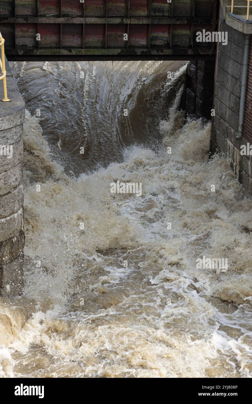 Powerful water flow surging through dam floodgates after heavy rainfall ...