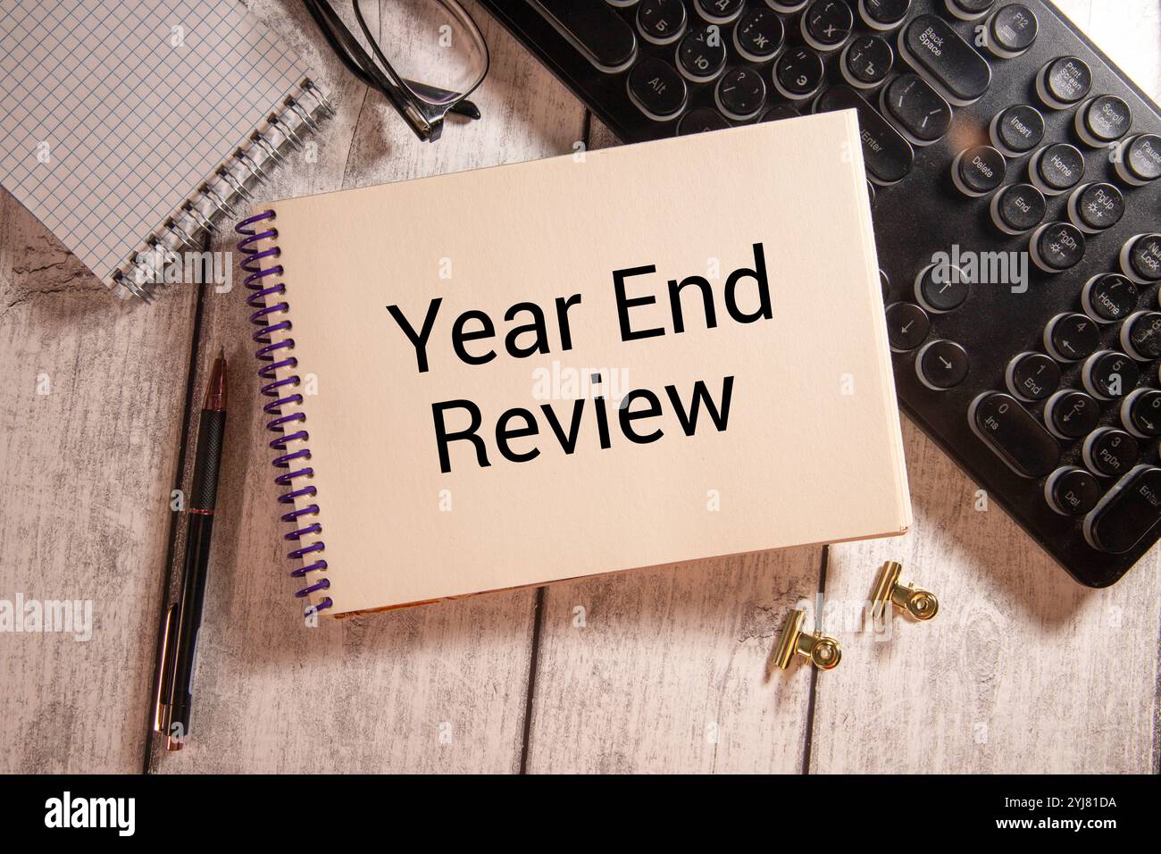 Year end review text on notepad with December calendar, glasses, calculator and pen. Year end ...
