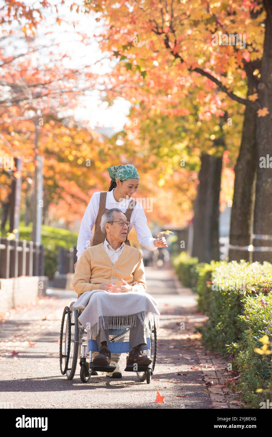 Senior man in wheelchair and care helper Stock Photo - Alamy