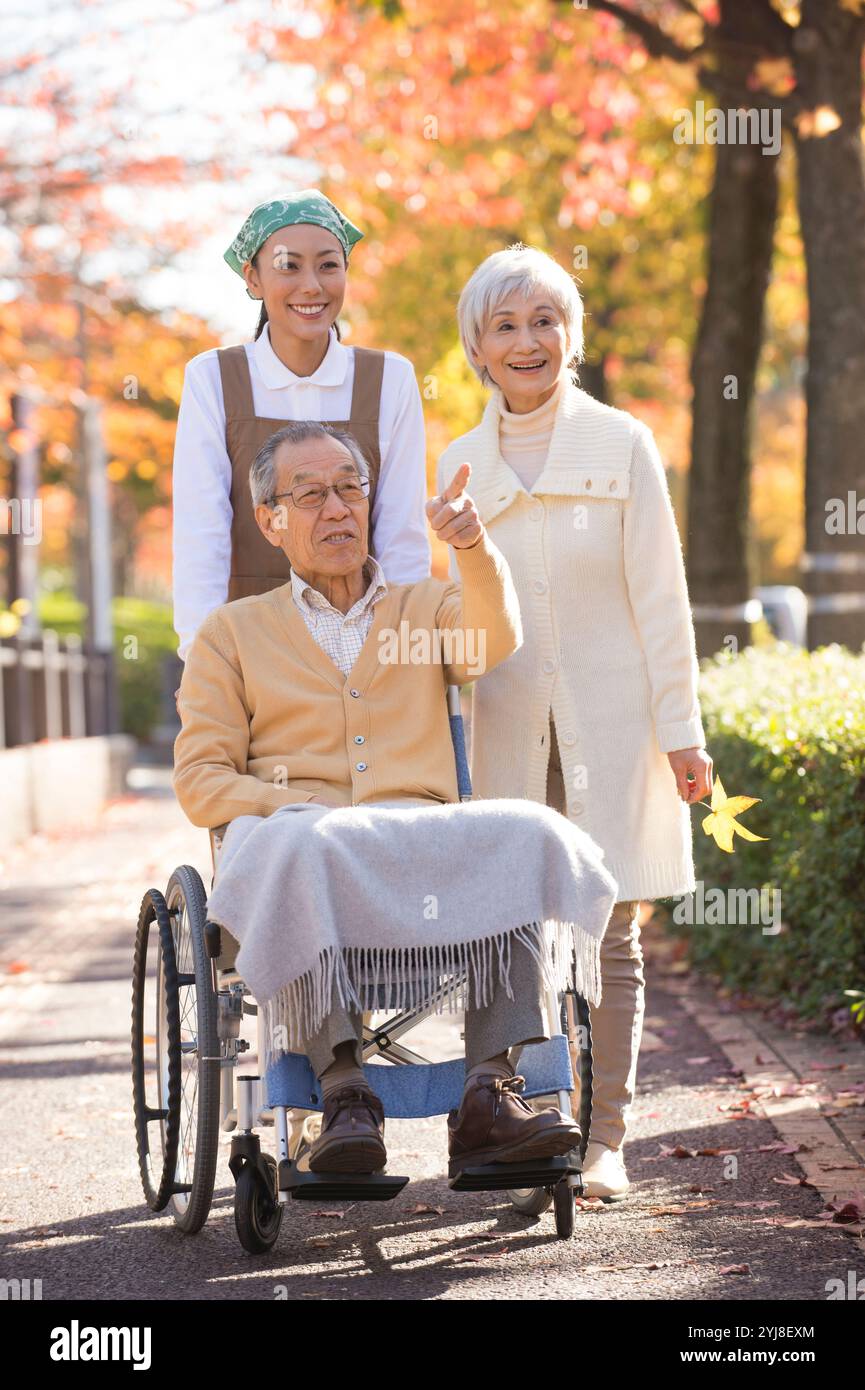 Senior couple in wheelchair and care helper Stock Photo - Alamy