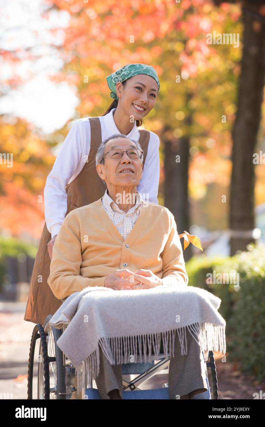Senior man in wheelchair and care helper Stock Photo - Alamy