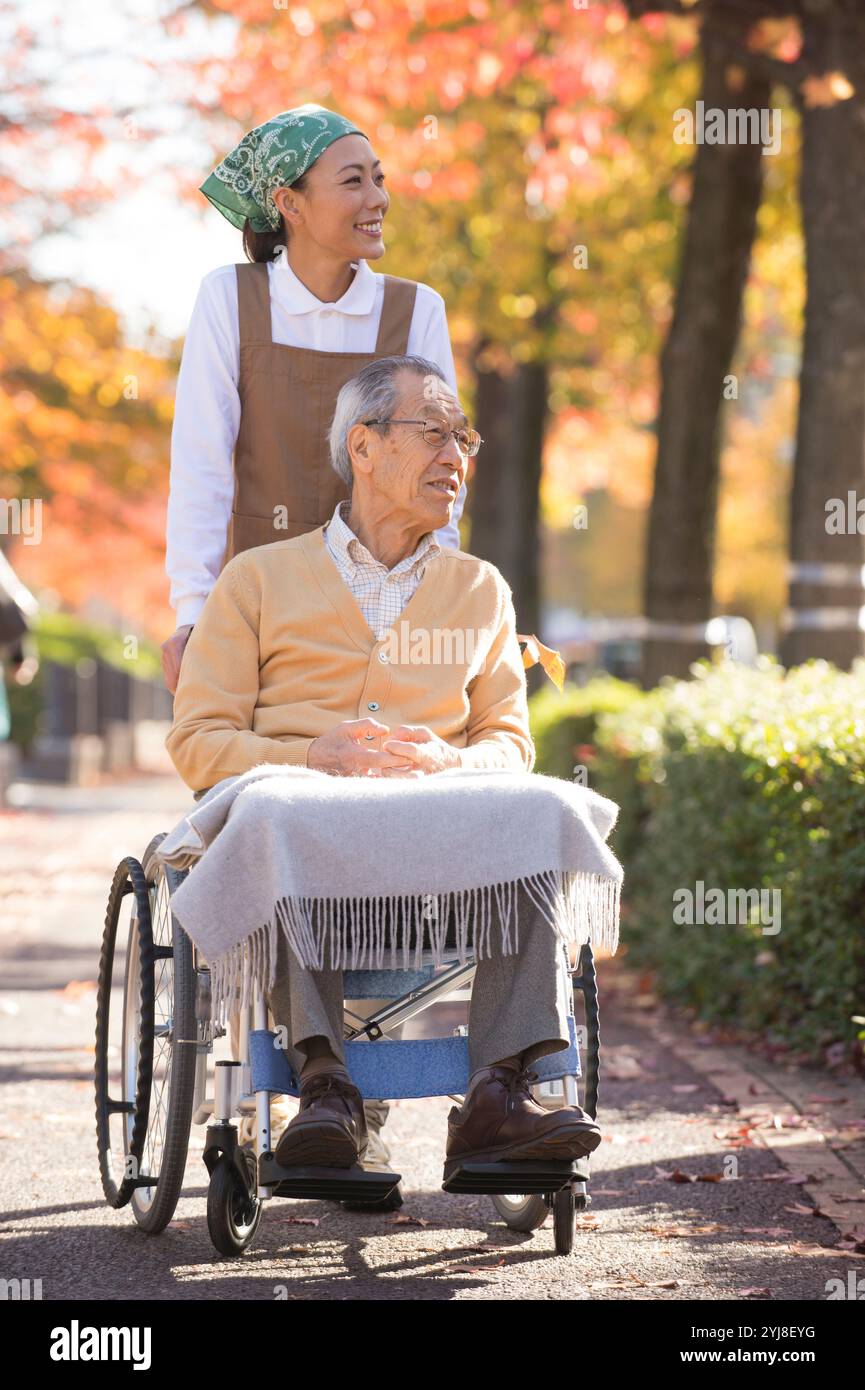 Senior man in wheelchair and care helper Stock Photo - Alamy