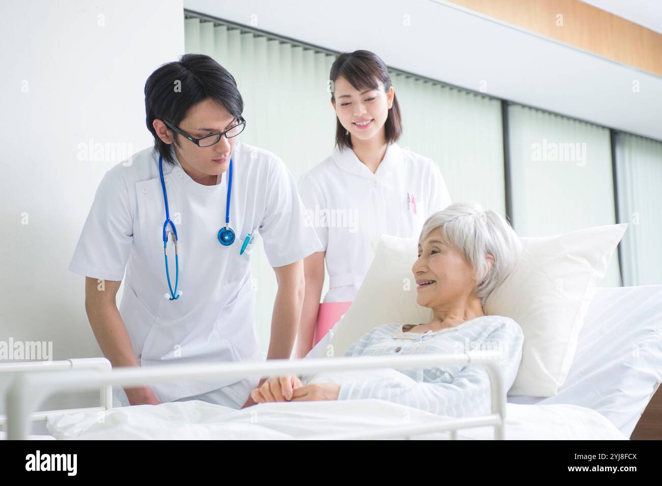 Doctor and nurse examining a hospitalised senior patient in bed Stock ...