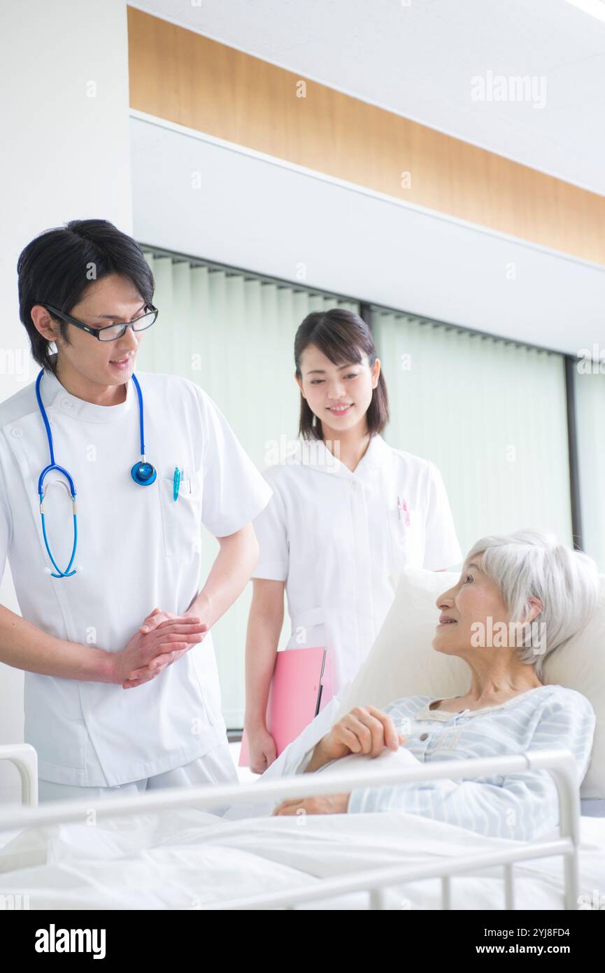 Doctor and nurse examining a hospitalised senior patient in bed Stock ...
