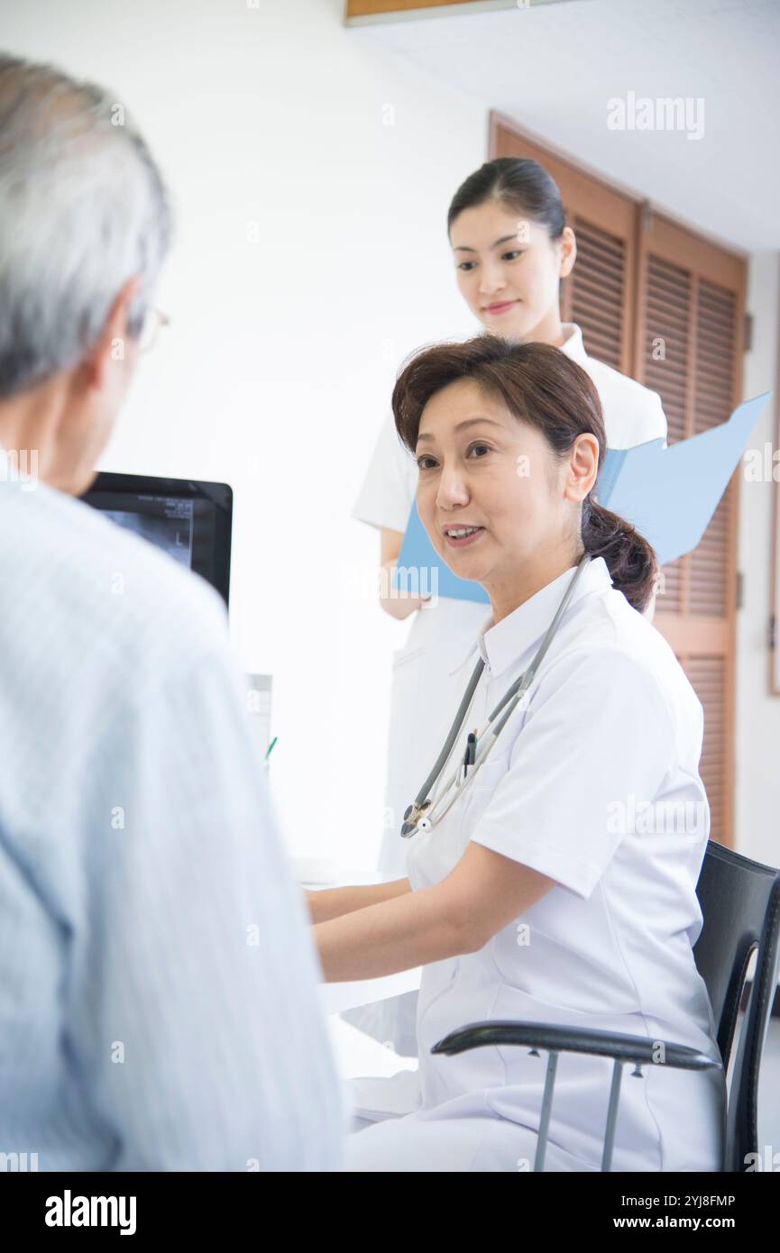 Senior male patients and nurses visiting a female doctor Stock Photo ...