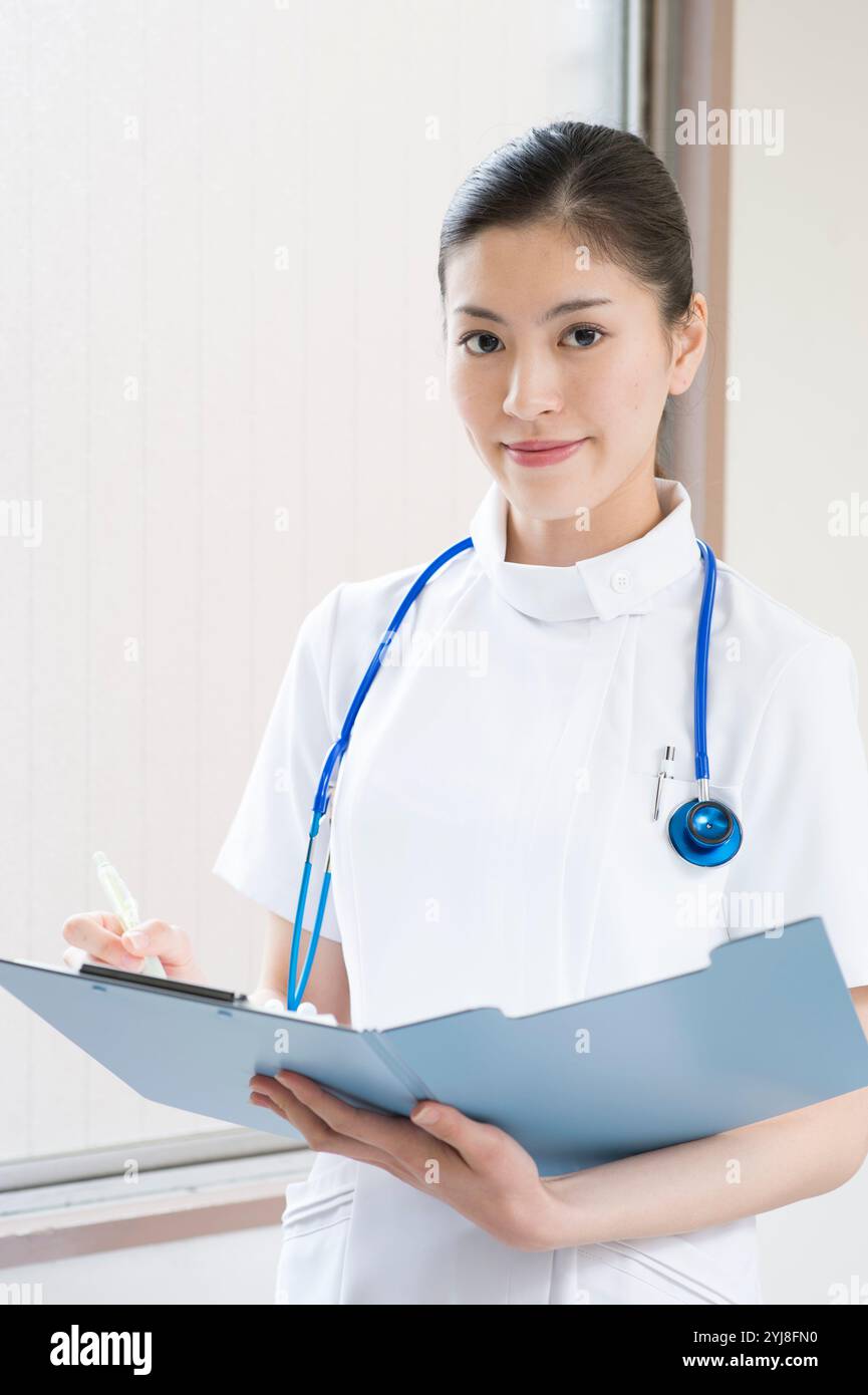 Nurse with stethoscope around neck and file Stock Photo - Alamy