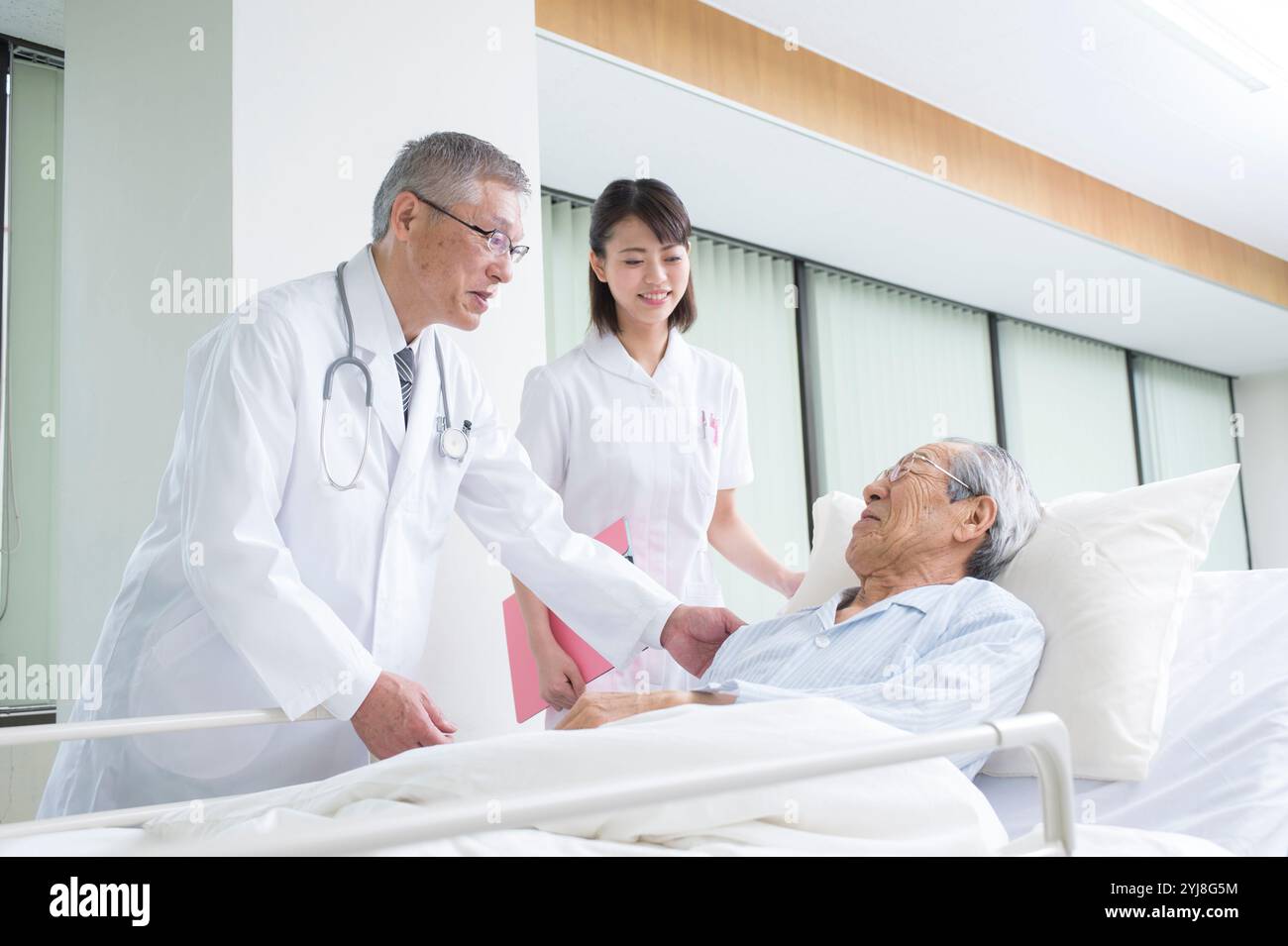 Doctor and nurse examining a hospitalised senior patient in bed Stock ...