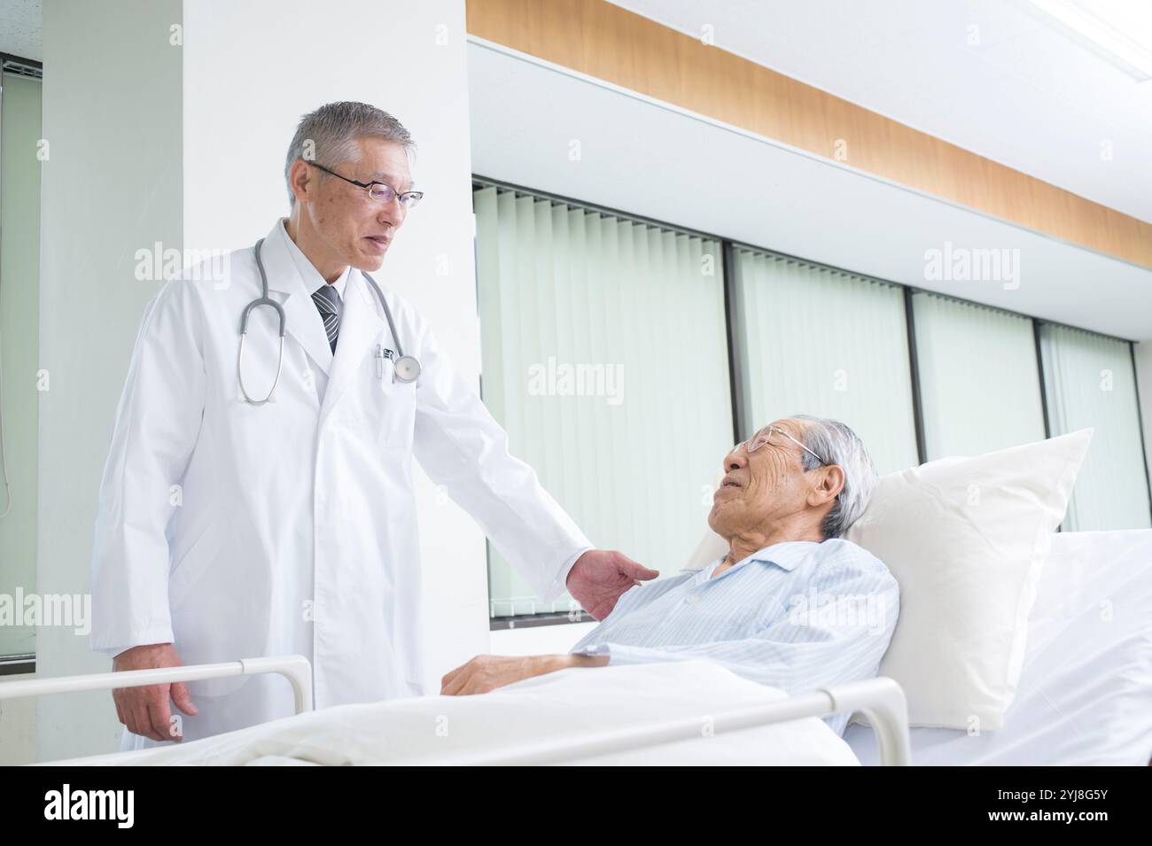 Doctor examining hospitalised senior patient in bed Stock Photo - Alamy