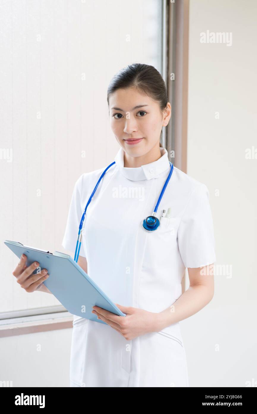 Nurse with stethoscope around neck and file Stock Photo - Alamy