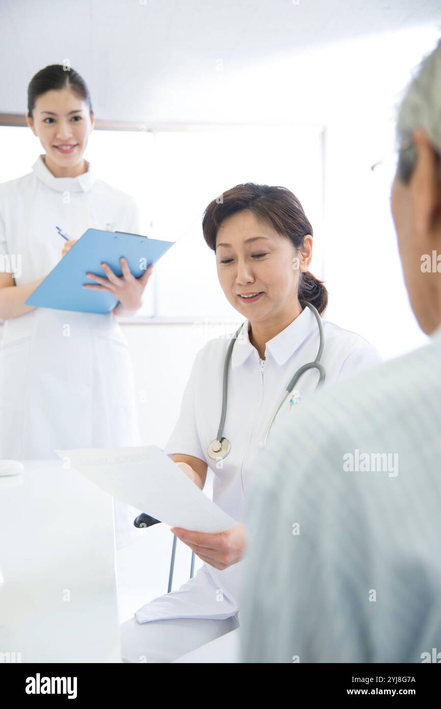 Senior male patients and nurses visiting a female doctor Stock Photo ...